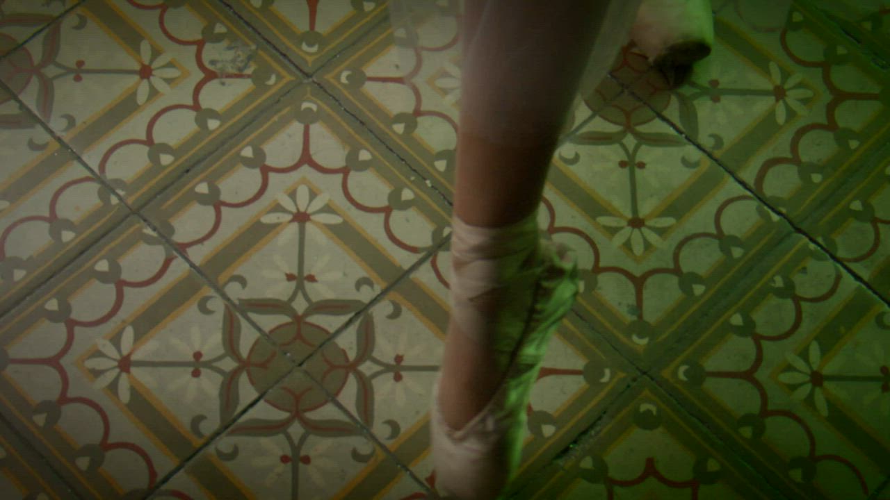 Camera captures the ballerina's feet dancing under the translucent tutu ...