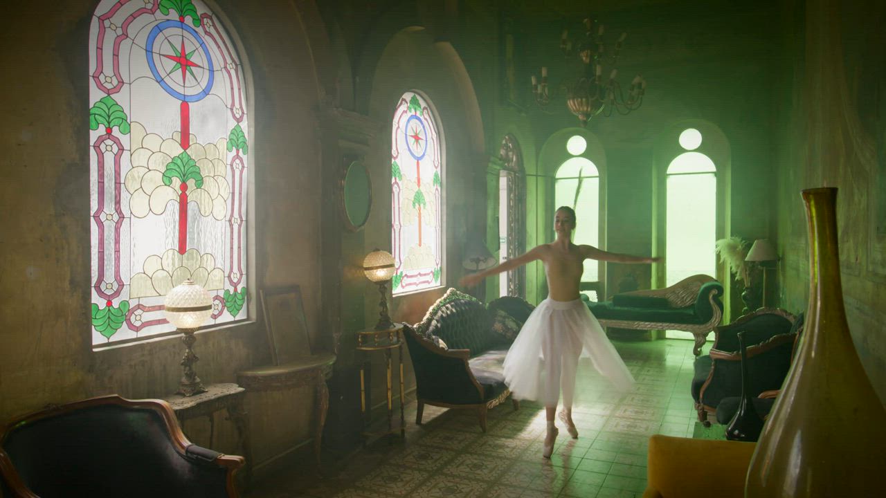 A young ballet ballerina with a translucent tutu dress spins and ...