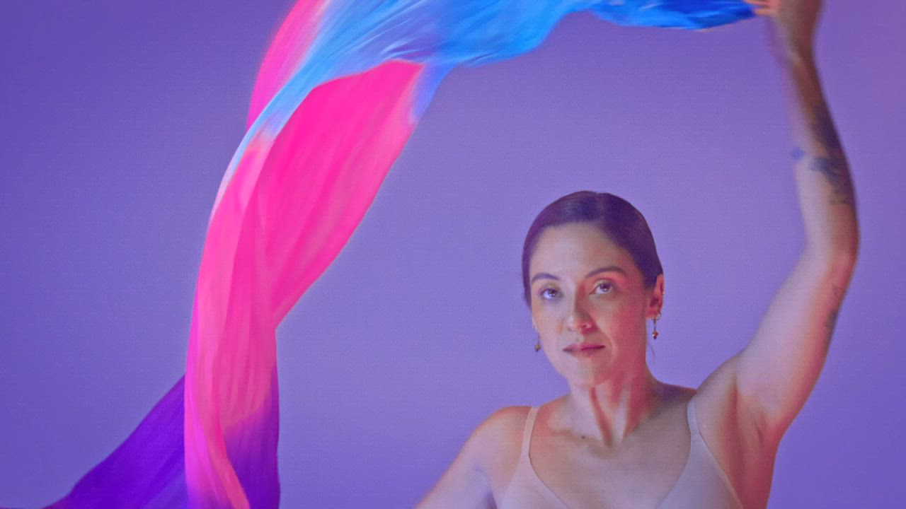 A concentrated ballerina gracefully moves the purple and pink ribbon ...