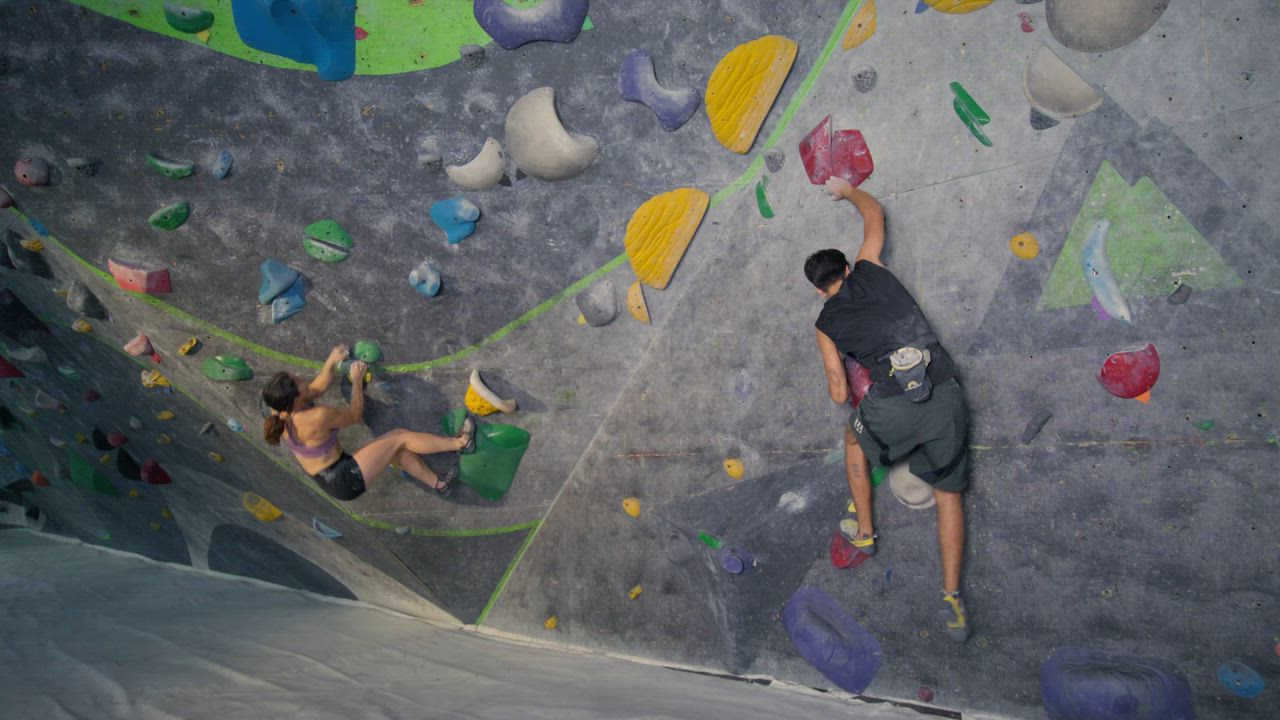 A couple training by climbing a wall - Free Stock Video