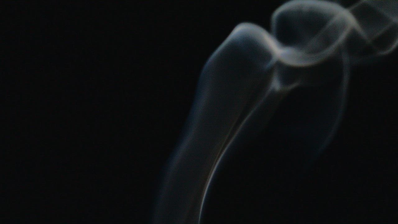 Soft and traslucent smoke flows up on a dark background - Free Stock Video