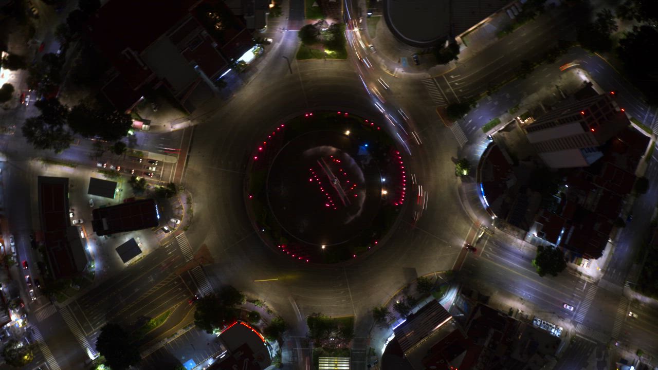 Top aerial video of the traffic around going a roundabout at night ...