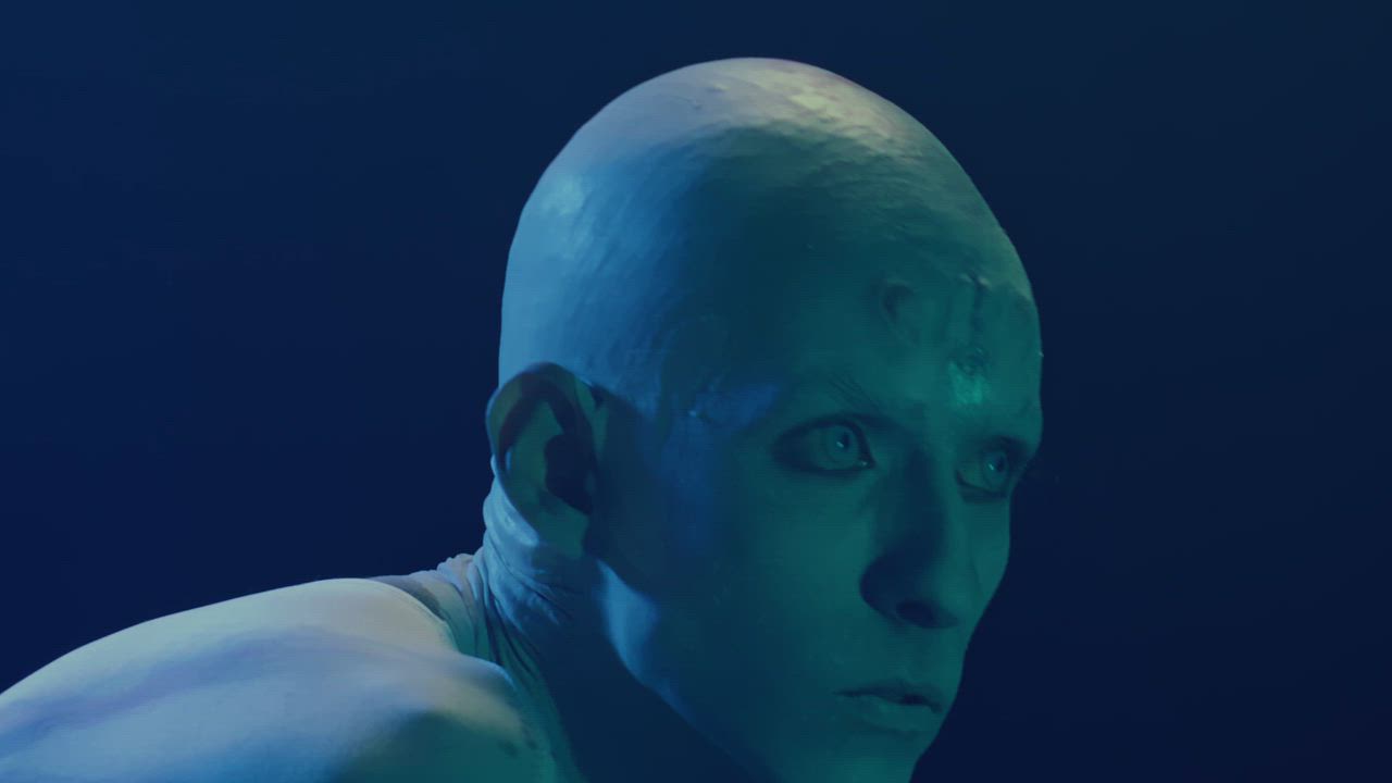 A pale skin alien monster looks in every direction in a bewildered way ...