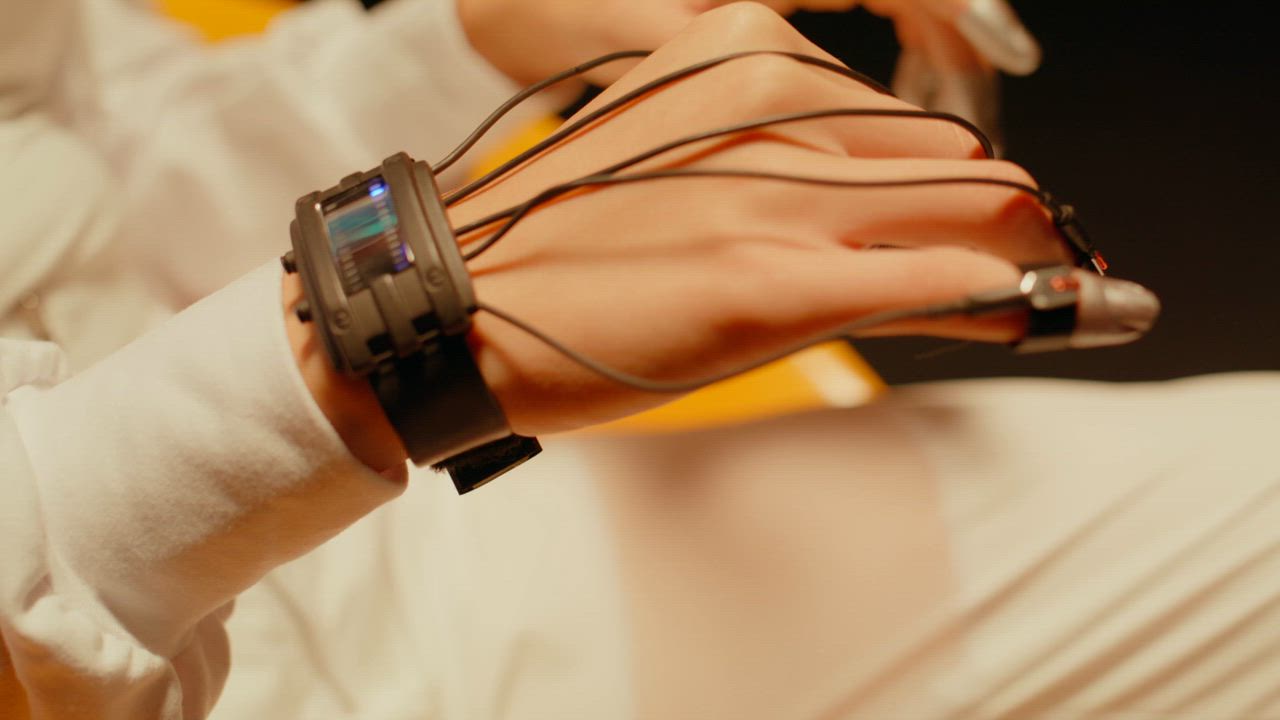 A futuristic electronic controller device on the hand makes subtle hand ...