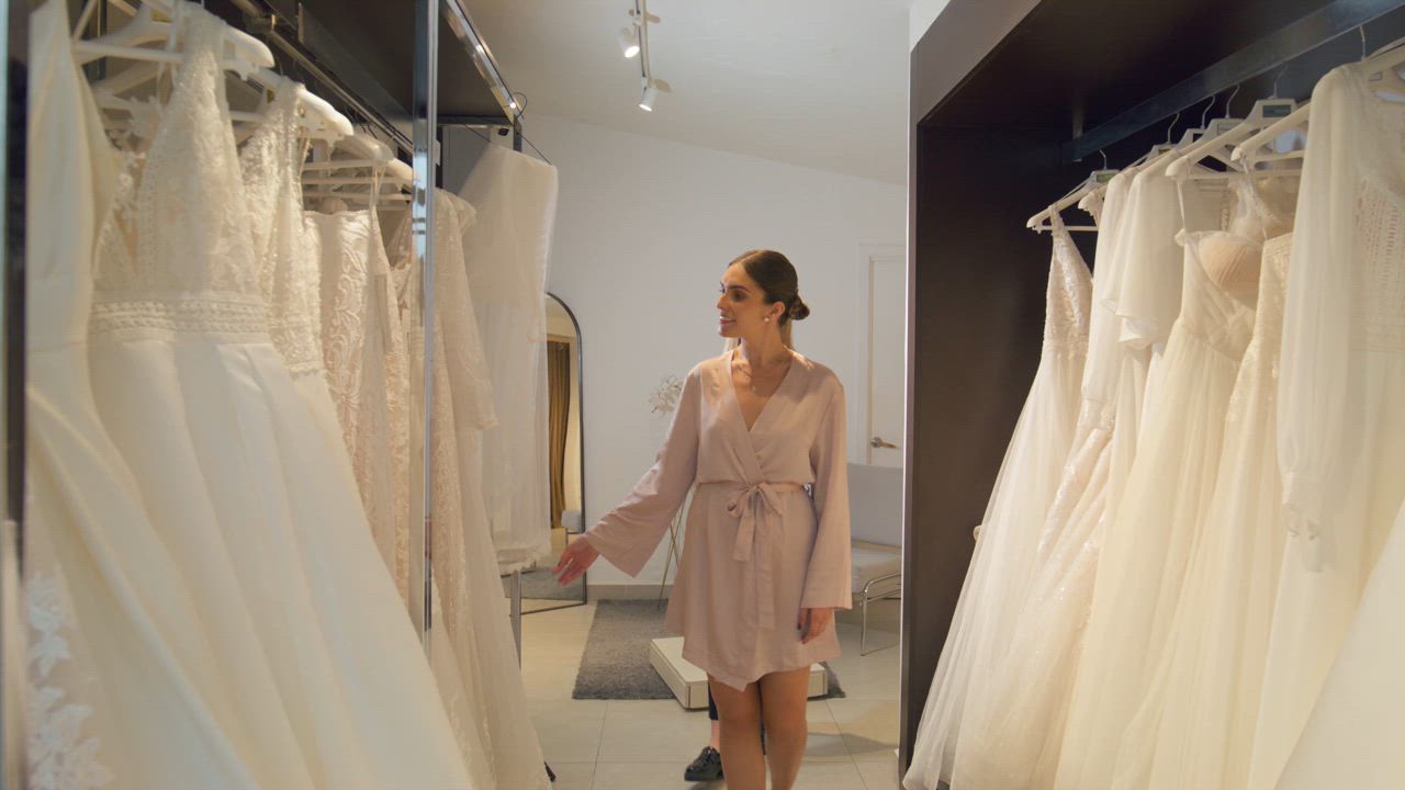 A young woman viewing bride dresses - Free Stock Video