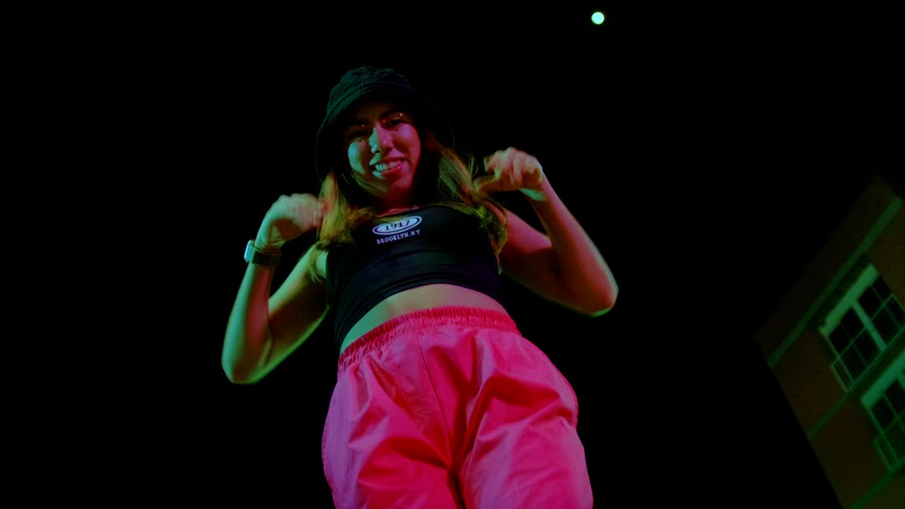 Girl dancing in slow motion in a neighborhood at night - Free Stock Video