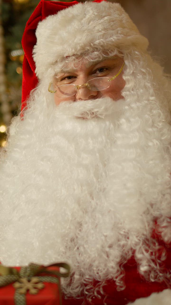 A charming Santa Claus delivers a gift carefully wrapped in red ...