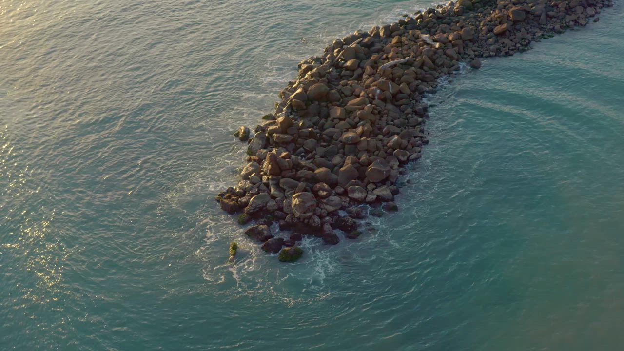 Small peninsula made of rocks in an aerial shot - Free Stock Video