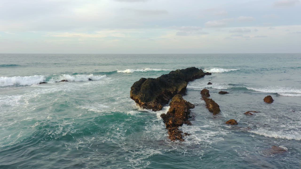 Waves hitting a small cliff on the seashore - Free Stock Video
