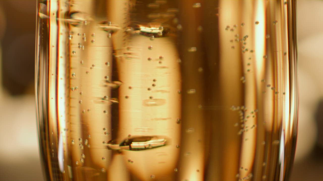 Close up shot of a golden bubbly drink that creates a mesmerizing ...
