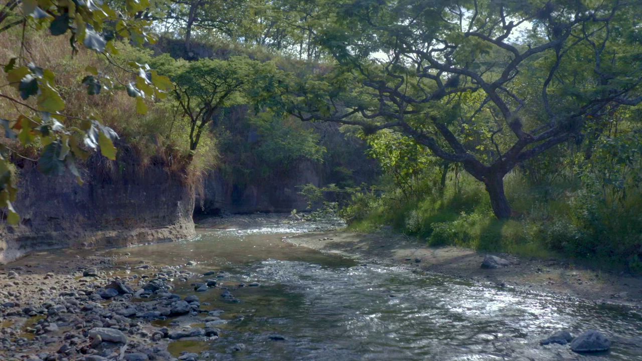 Flying over a relaxing creek full of rock on the countryside - Free Stock Video