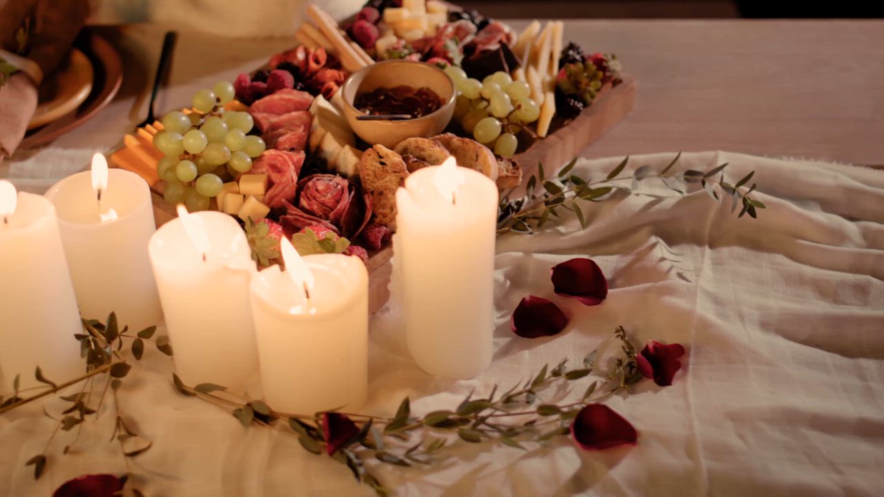 A couple enjoy a date with a romantic adorned table including candles ...