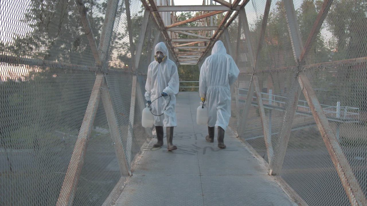 People with masks sanitizing a pedestrian bridge - Free Stock Video