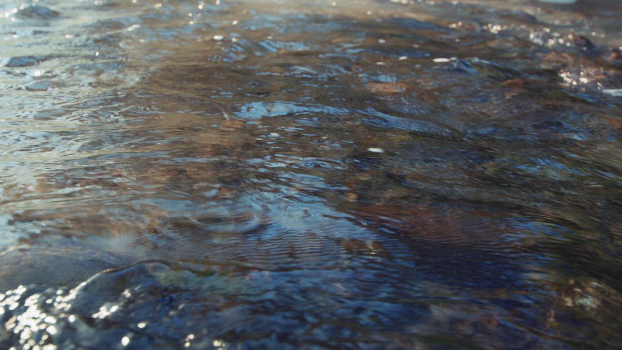 A continuous flow of the river water over the smooth stones in the ...