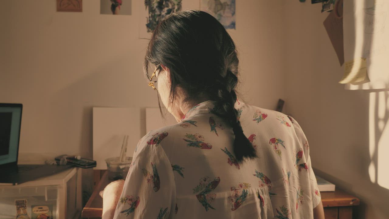Artist seen from behind painting in her studio - Free Stock Video