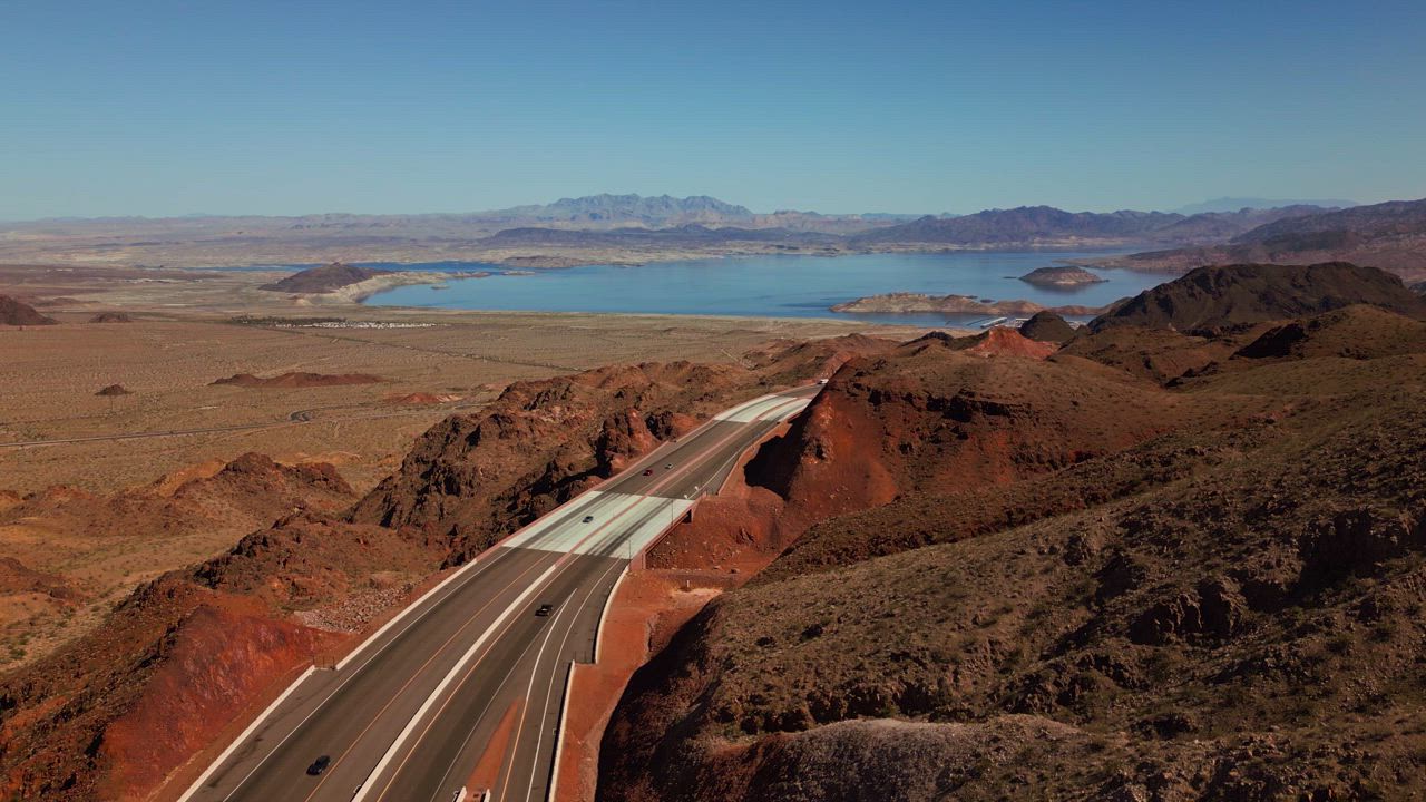 Road crossing an arid mountain range in an aerial shot - Free Stock Video