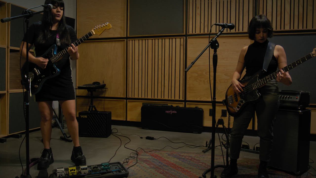 Two girls from a band playing together in a studio - Free Stock Video