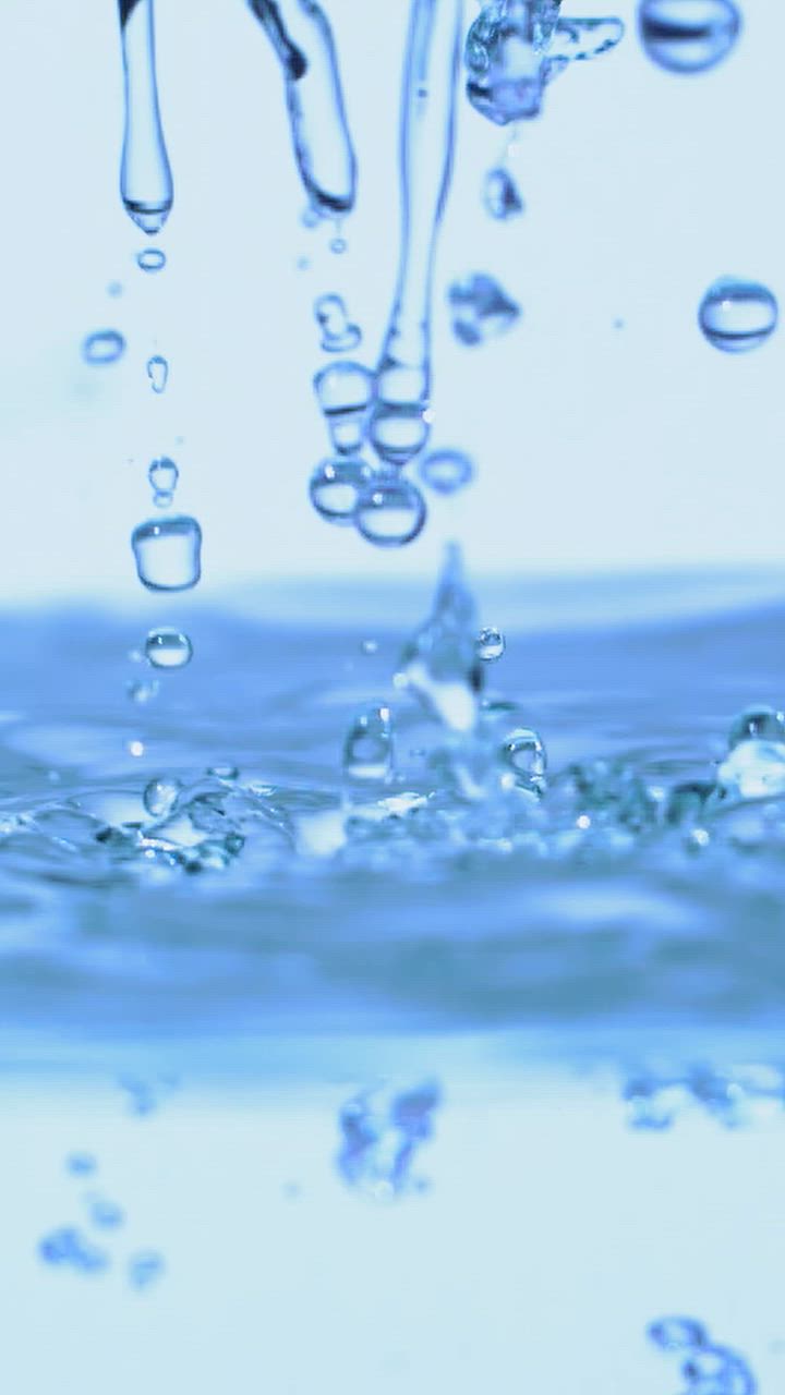 Thin streams of water falling on a water surface - Free Stock Video