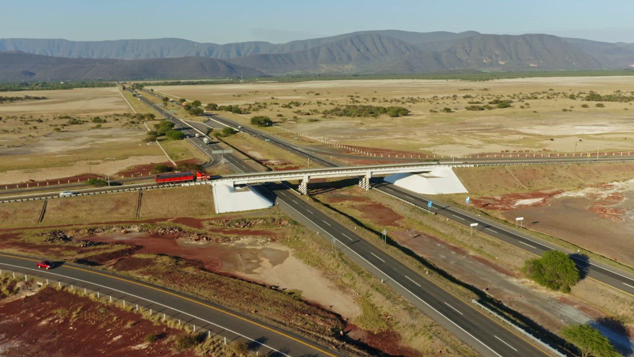 Aerial view of a highway overpass with a big red transport truck ...