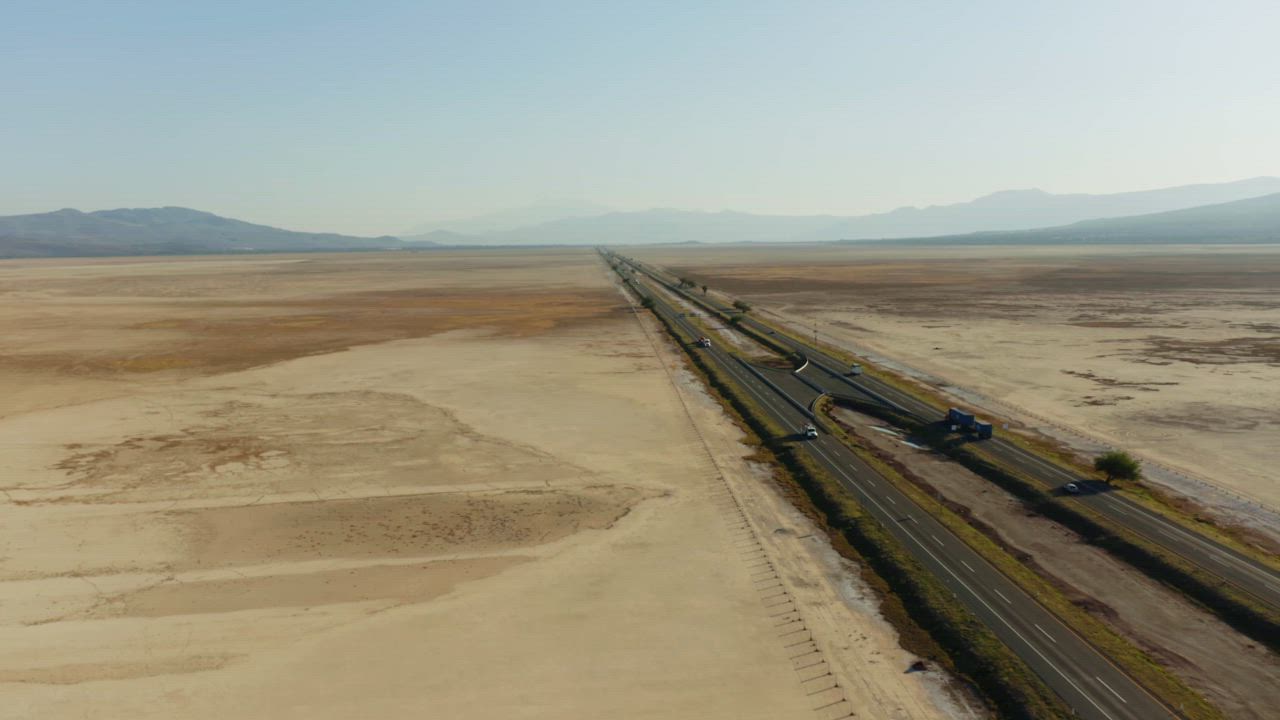 An expansive highway with a steady stream of trucks and vehicles in the ...