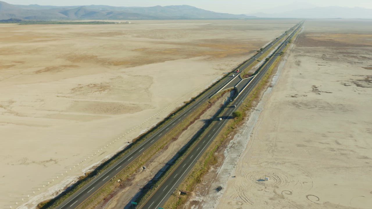 A steady stream of trucks and vehicles traversing the expansive highway ...