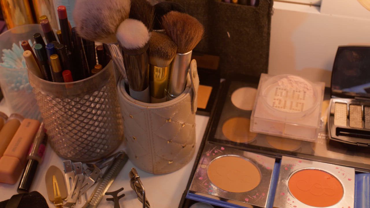 Make up artist table full of brushes, colorful eyeshadows and an ...