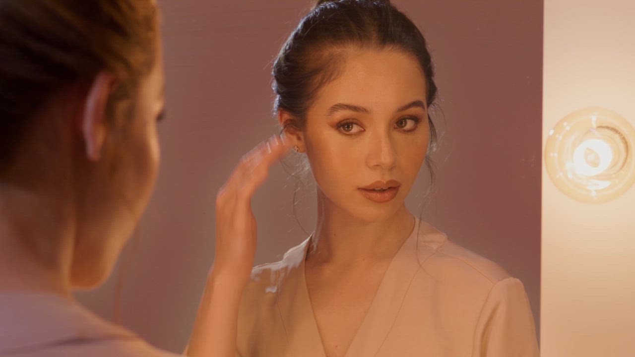 A young woman model checks her makeup at the mirror - Free Stock Video