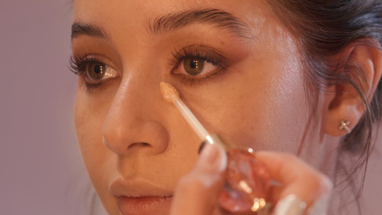 The make up artist add makeup foundation to the eyebags of a young ...