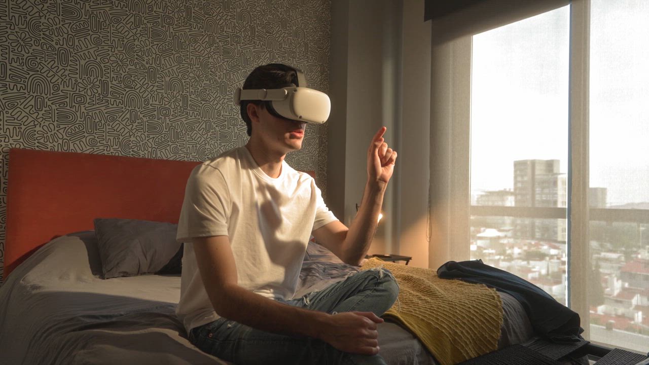 A young man wearing VR glasses is immersed in the virtual reality world ...