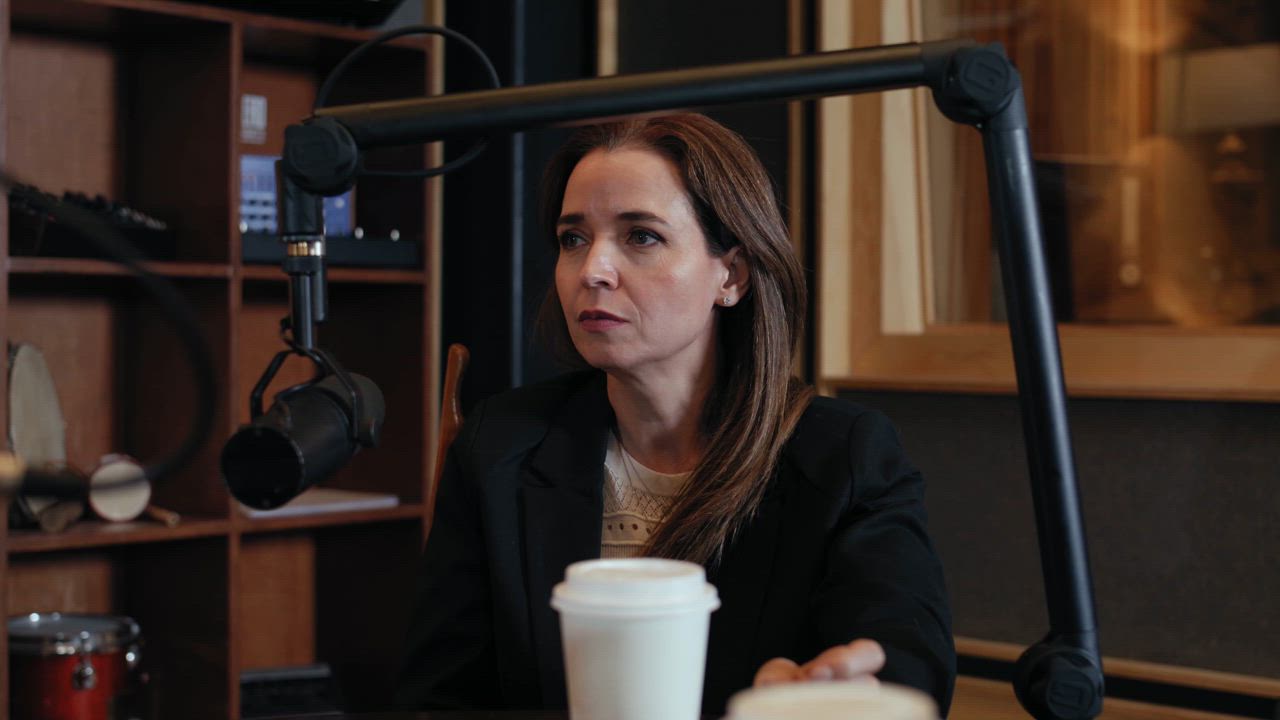 A mature extroverted woman smiles and responds with lively gestures in ...