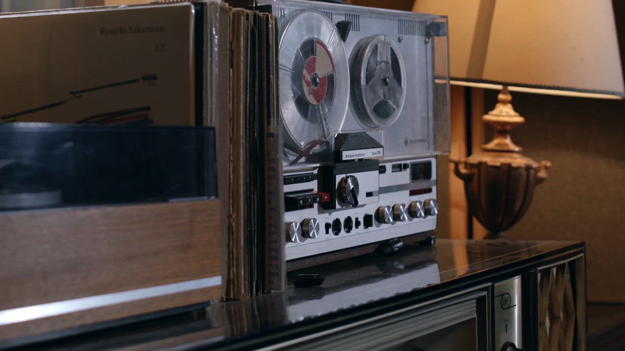 The camera gets closer to vintage reel-to-reel tape recorder placed on ...