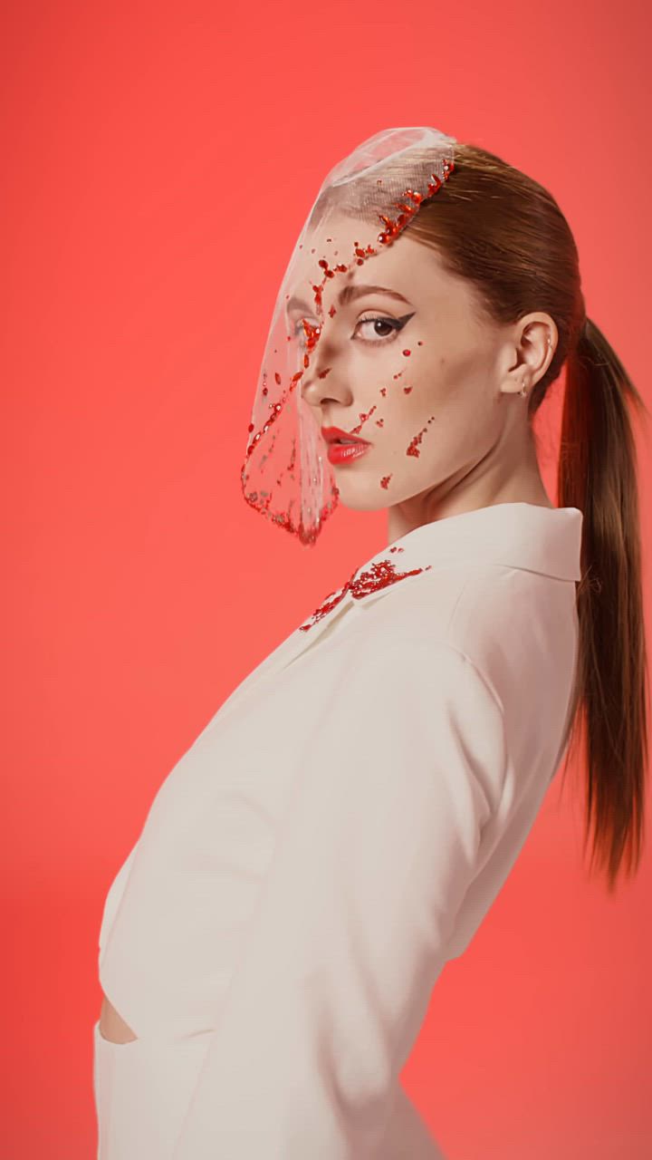 Vertical shot of a young woman wearing an elegant white attire ...