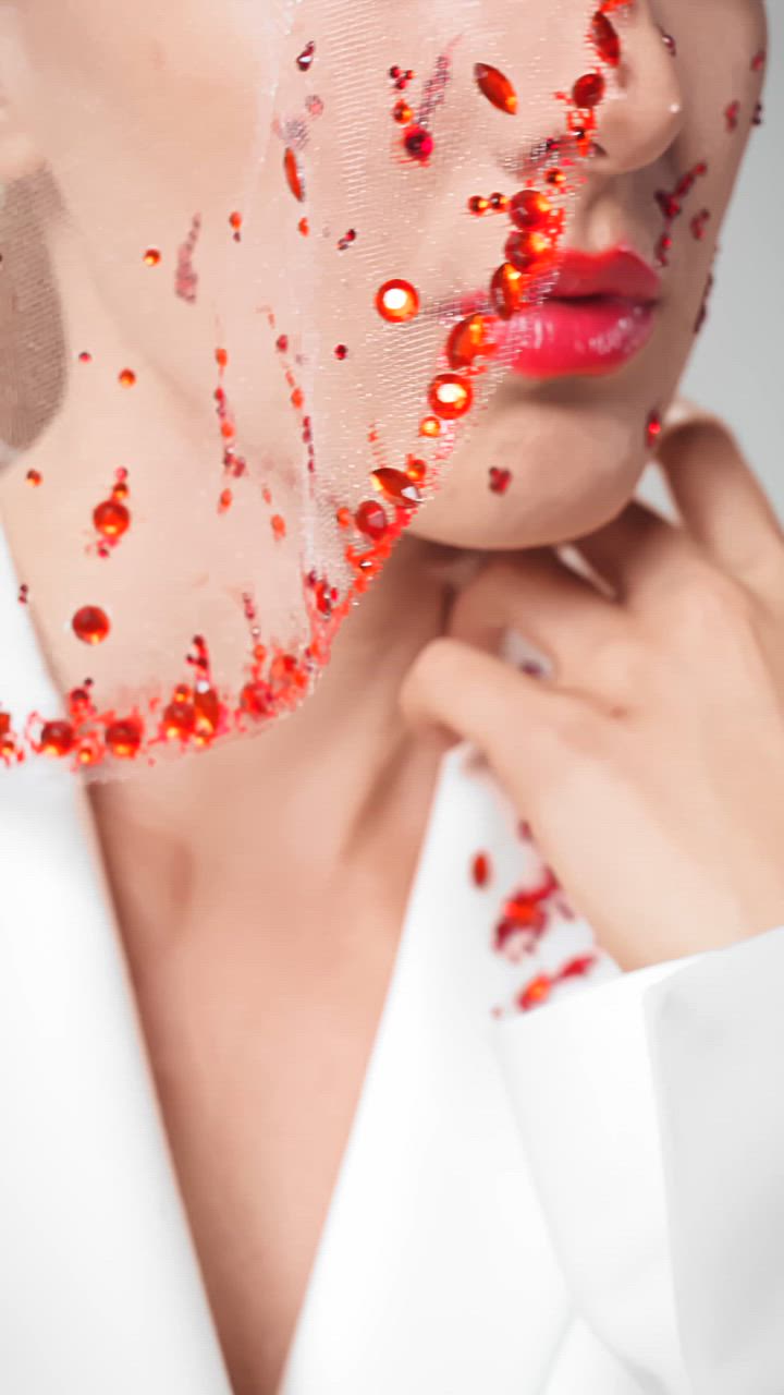 Vertical shot of a beautiful model posing with a white veil with shine ...