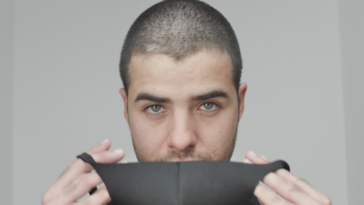 Man facing the camera while putting on a mask - Free Stock Video
