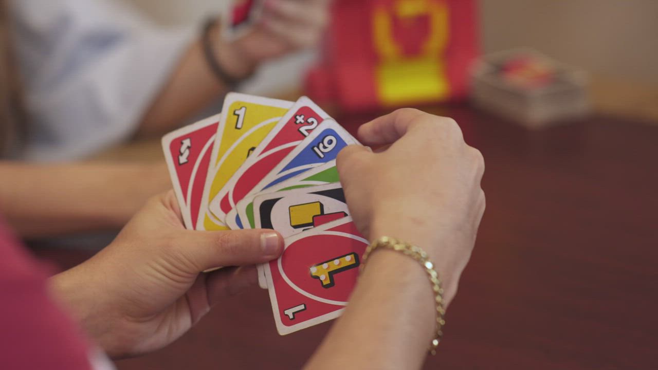 Hands of a person playing a game of UNO - Free Stock Video