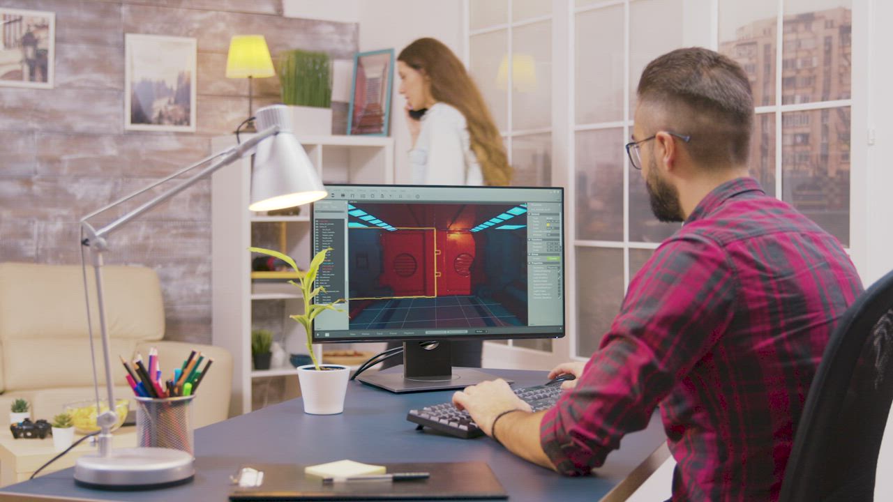 Game developer working from home viewed from behind - Free Stock Video