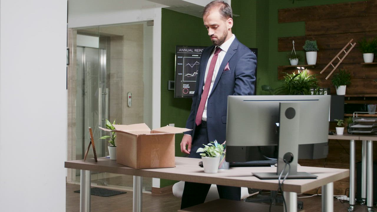 Failed man cleans out desk after losing job - Free Stock Video