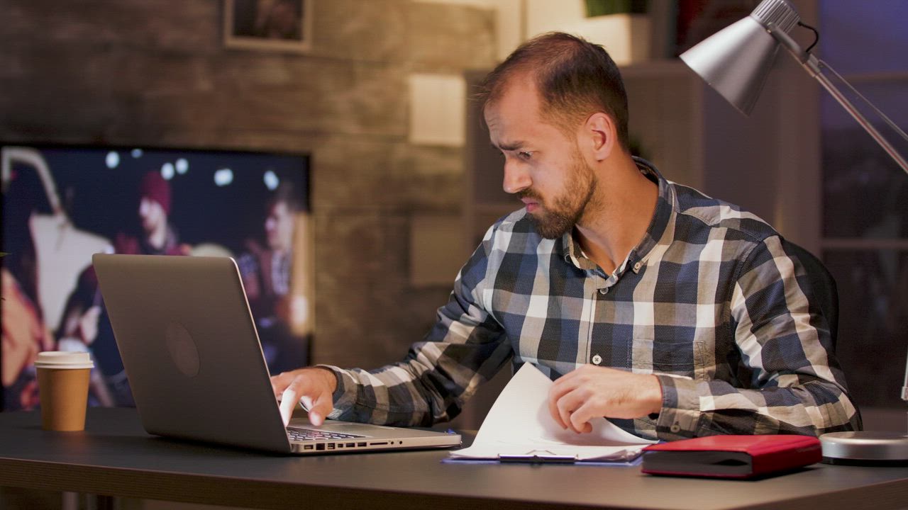 Man doing research on laptop from home office - Free Stock Video
