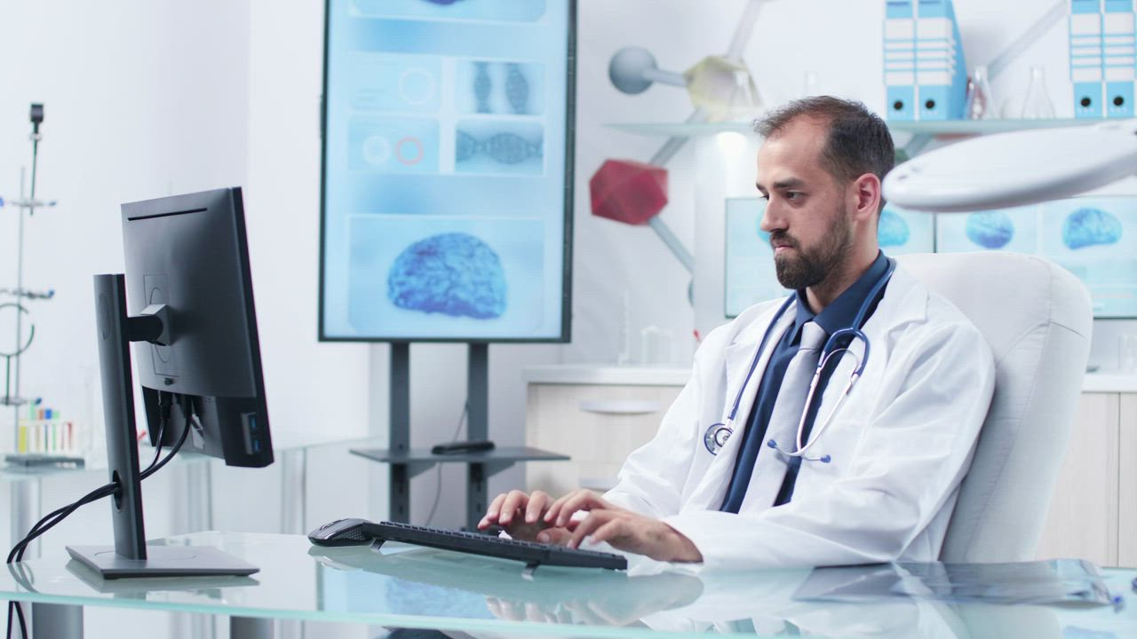 Doctor working in hospital office is handed reports - Free Stock Video