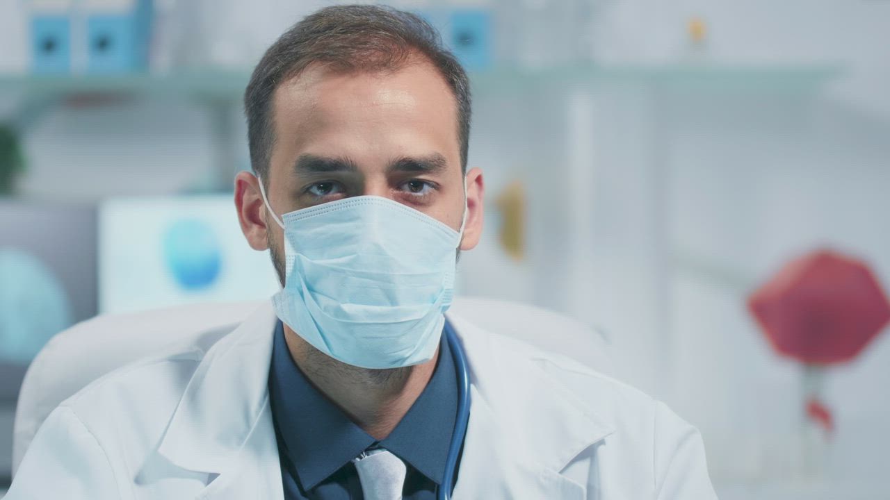 Modern hospital doctor in face mask nodding - Free Stock Video