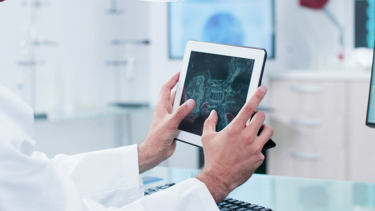 Doctor reviewing a scan on their tablet - Free Stock Video
