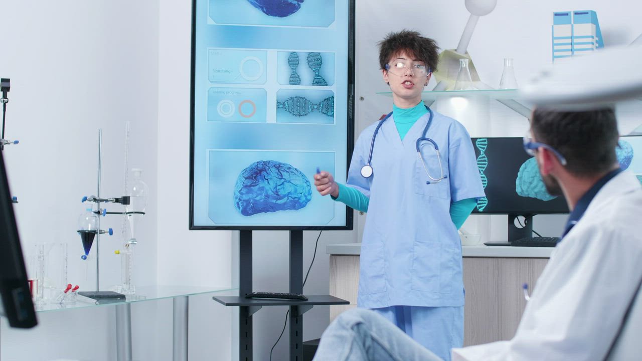 Doctors in futuristic lab discuss 3d brain models - Free Stock Video