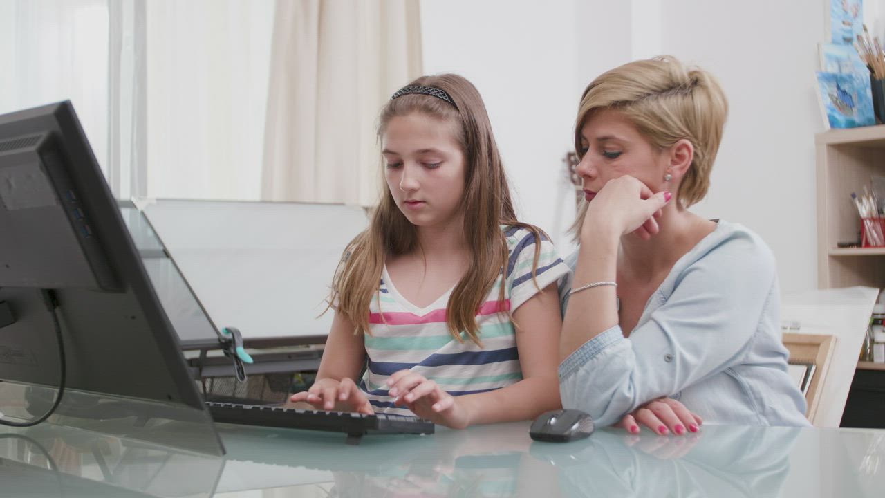 Mom helps daughter with distance learning on PC - Free Stock Video