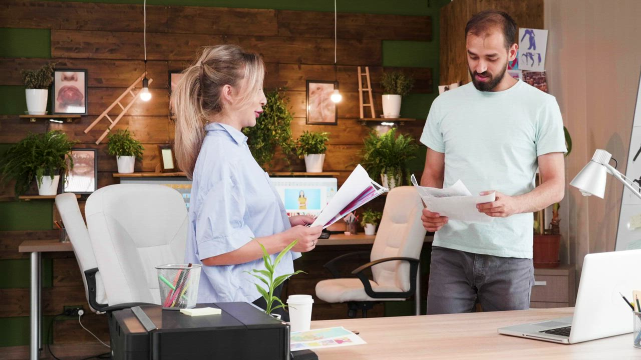 Creatives look through photo ideas in casual office - Free Stock Video