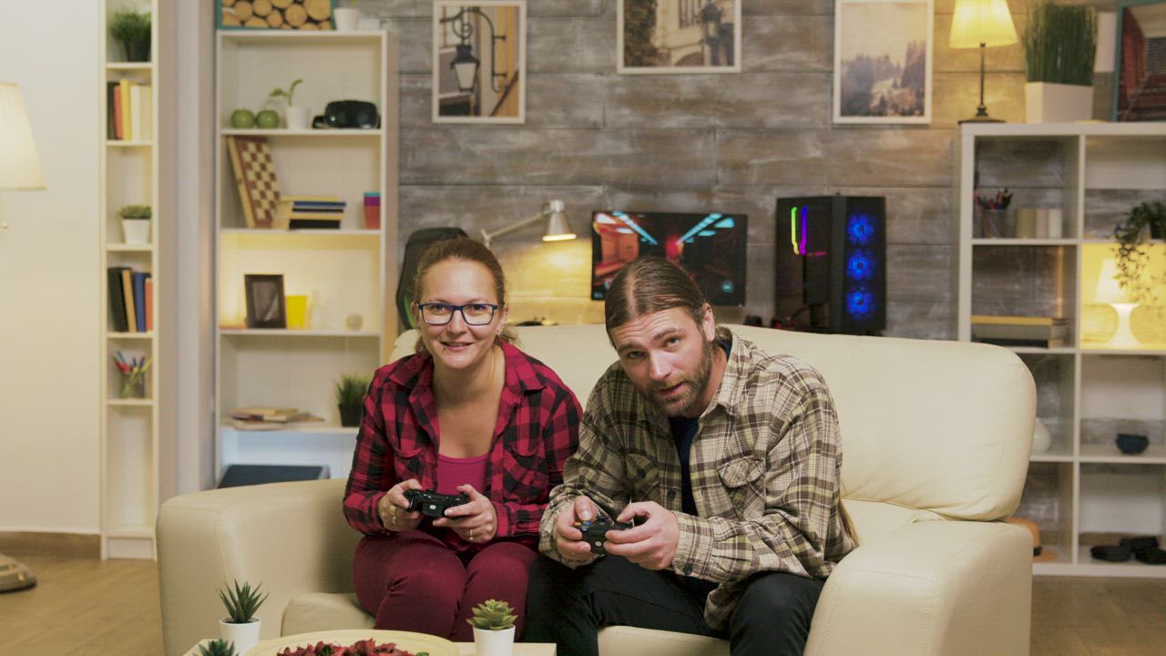 Gaming couple jump up to celebrate victory - Free Stock Video