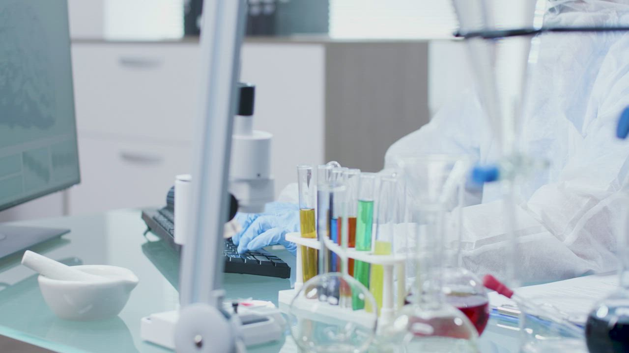 Chemist typing on a computer - Free Stock Video