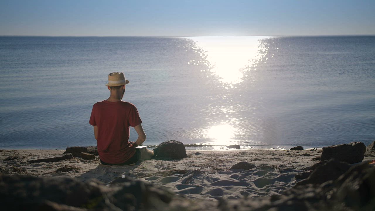 Man working remotely from the beach - Free Stock Video