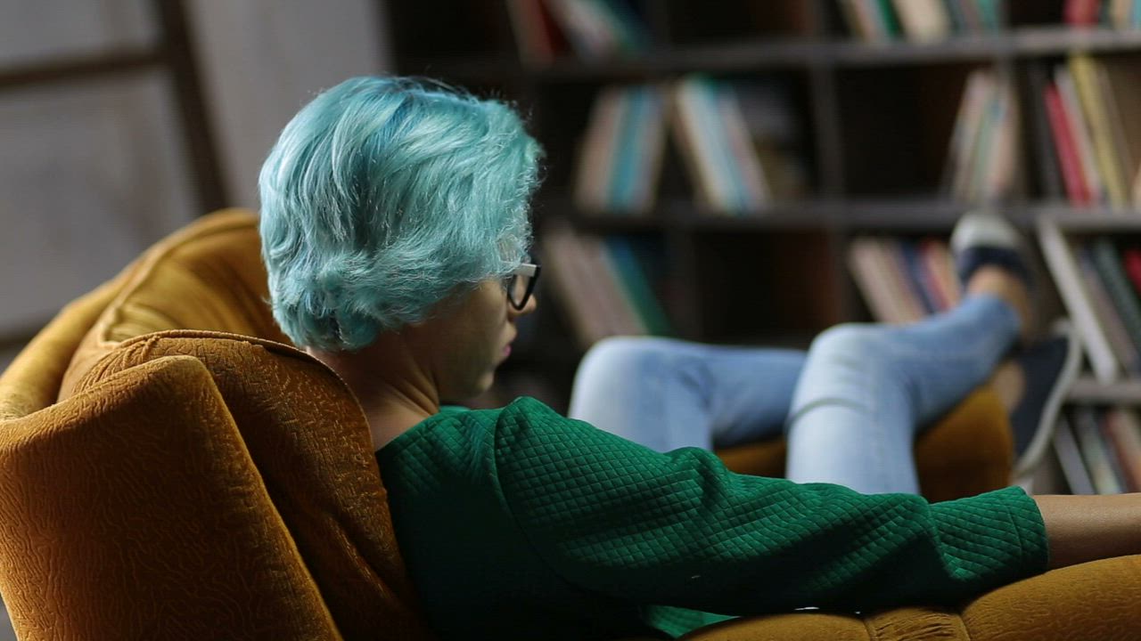 Woman relaxing in the library - Free Stock Video