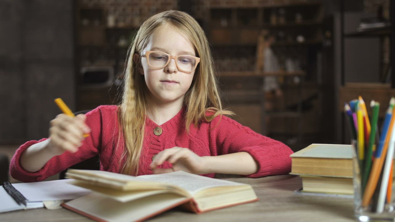 Girl reading a book while writing - Free Stock Video