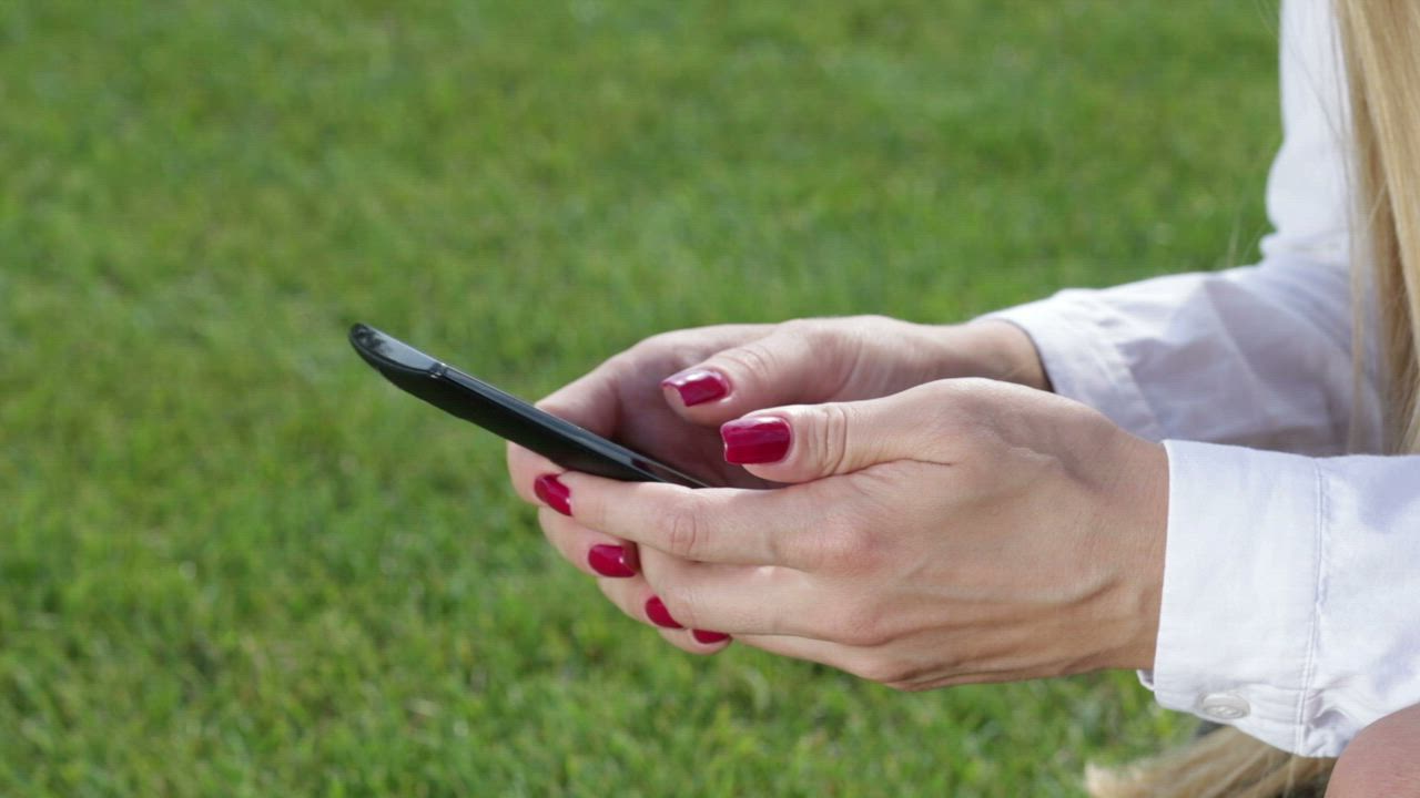 Woman scrolling through her phone - Free Stock Video